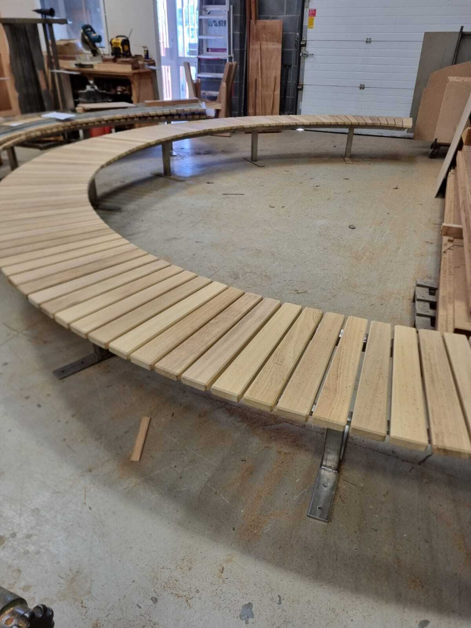 Two curved benches in stainless steel and hardwood for NHS site ...